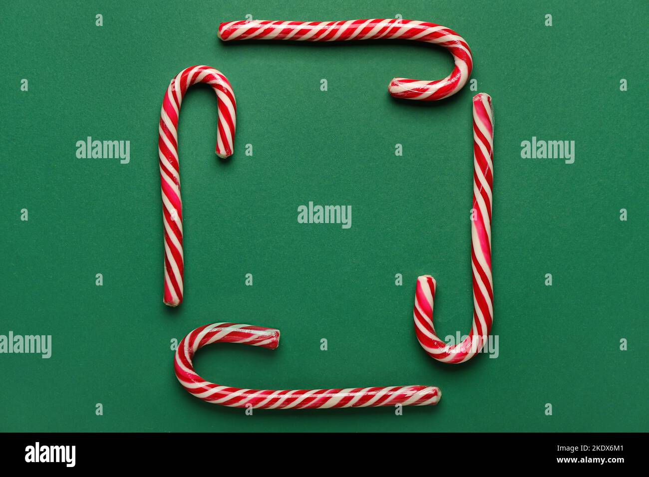 Frame made of candy canes on green background Stock Photo - Alamy