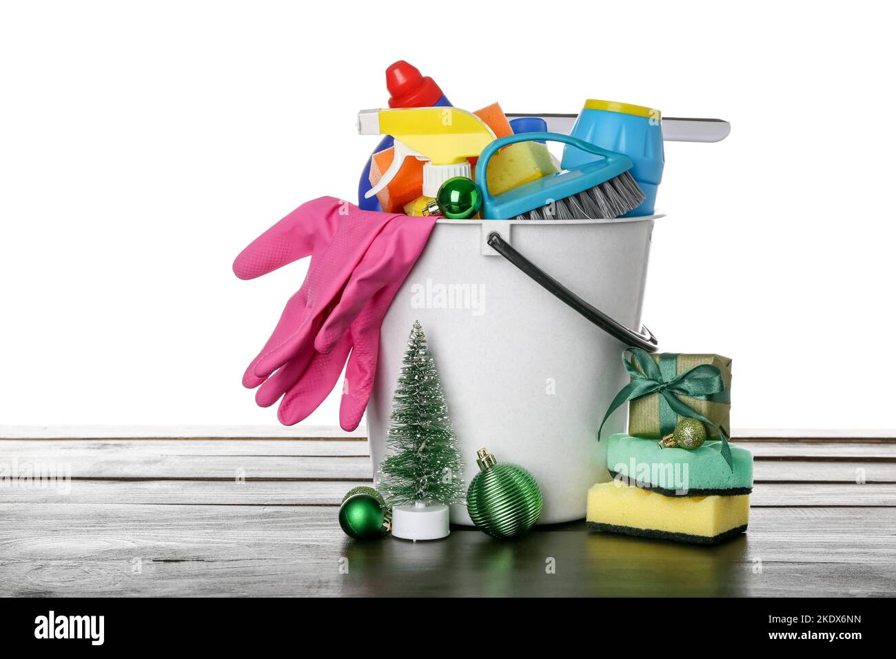 Bucket with cleaning supplies and Christmas decor on table against ...