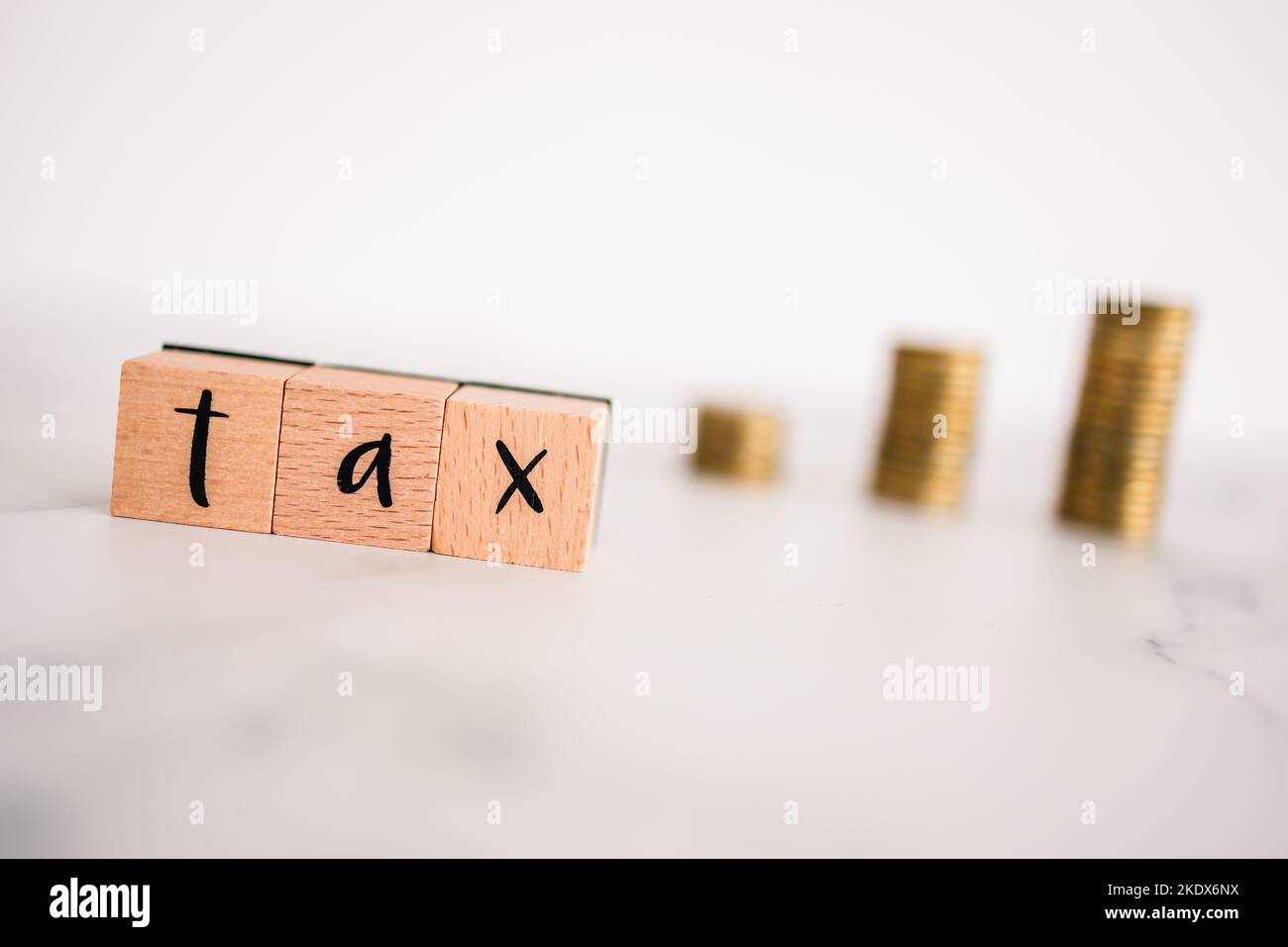 Tax text on top of growing stacks of coins, symbol of increasing tax ...