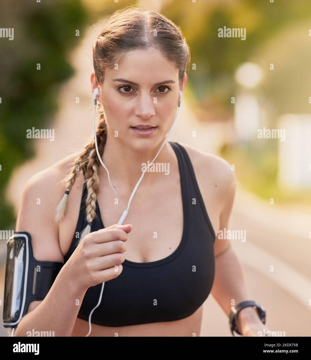 Focused on the next step. an attractive young woman listening to music ...