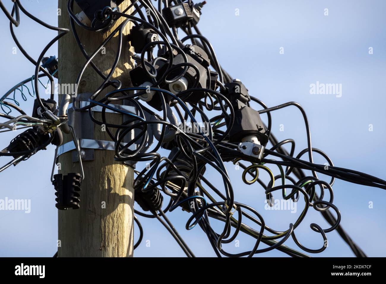 Top of a pole with a lot of power wires is under blue sky Stock Photo ...