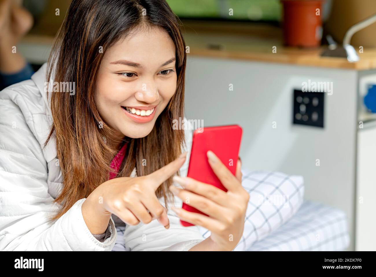Asian woman using mobile phone inside the campervan enjoying camp ...