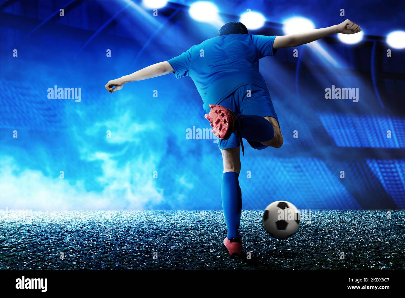 Rear view of a football player man in a blue jersey kicking the ball on ...