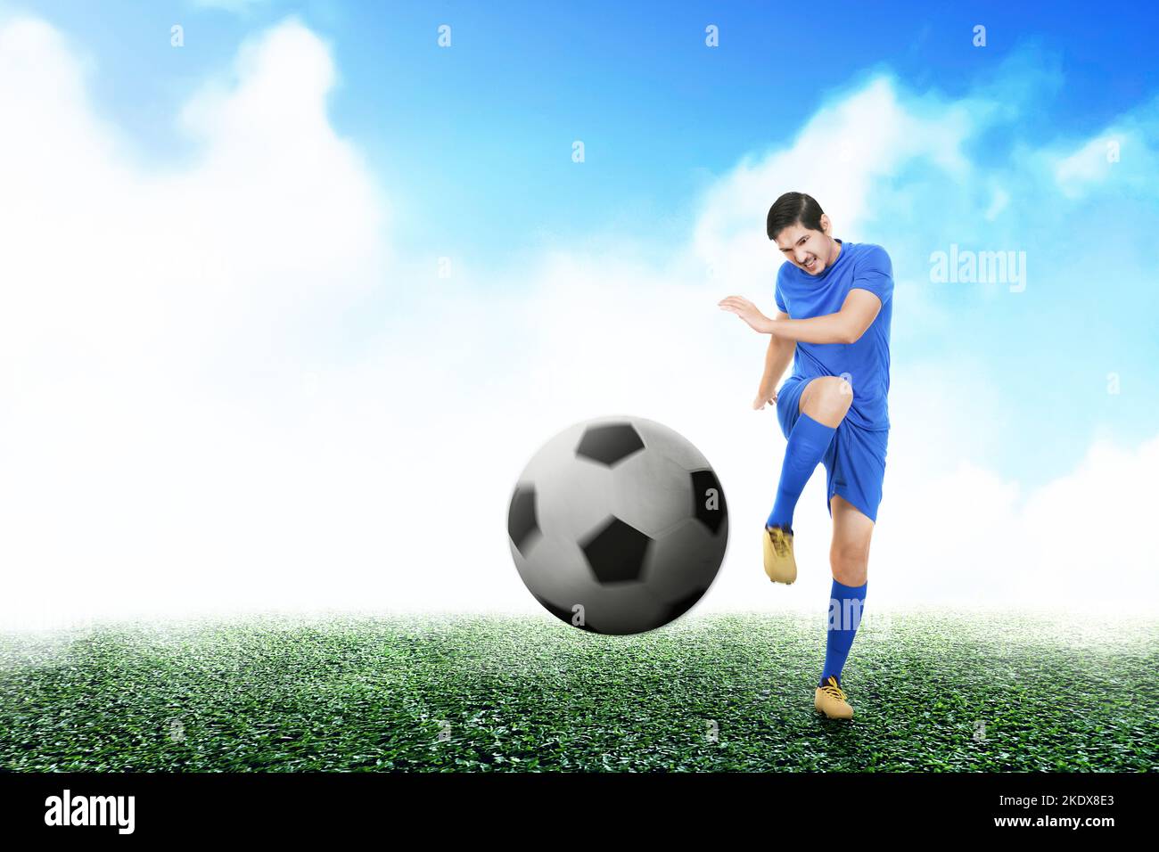 Asian football player man in a blue jersey kicking the ball on the ...