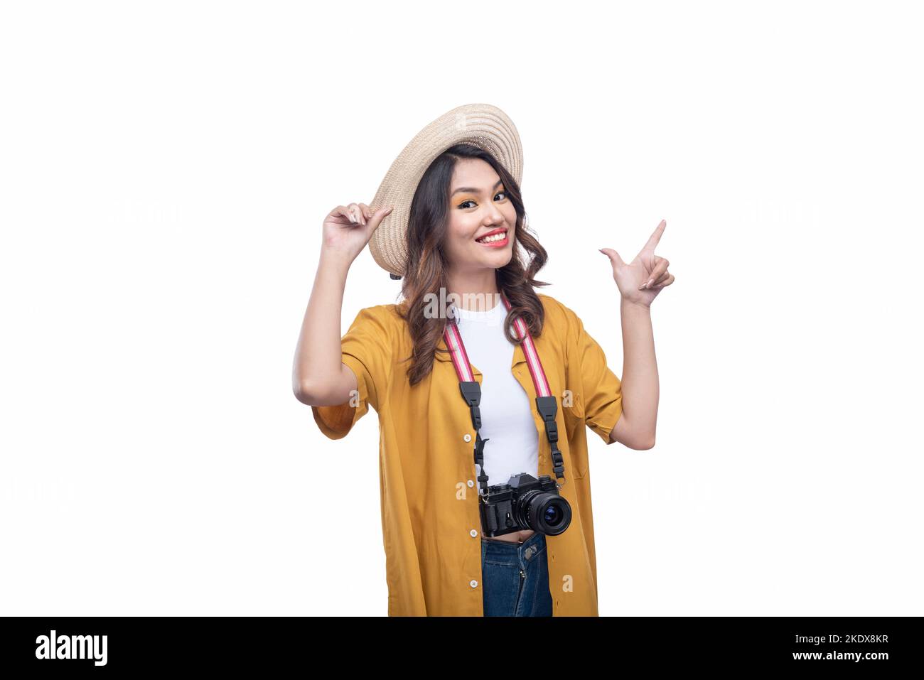 Asian woman with a hat and camera pointing at something isolated over ...