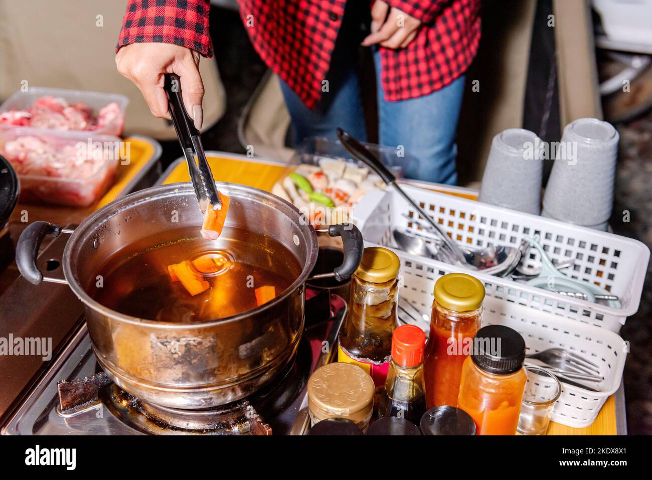 Women cooking steamboat while enjoying camp activity in nature Stock ...