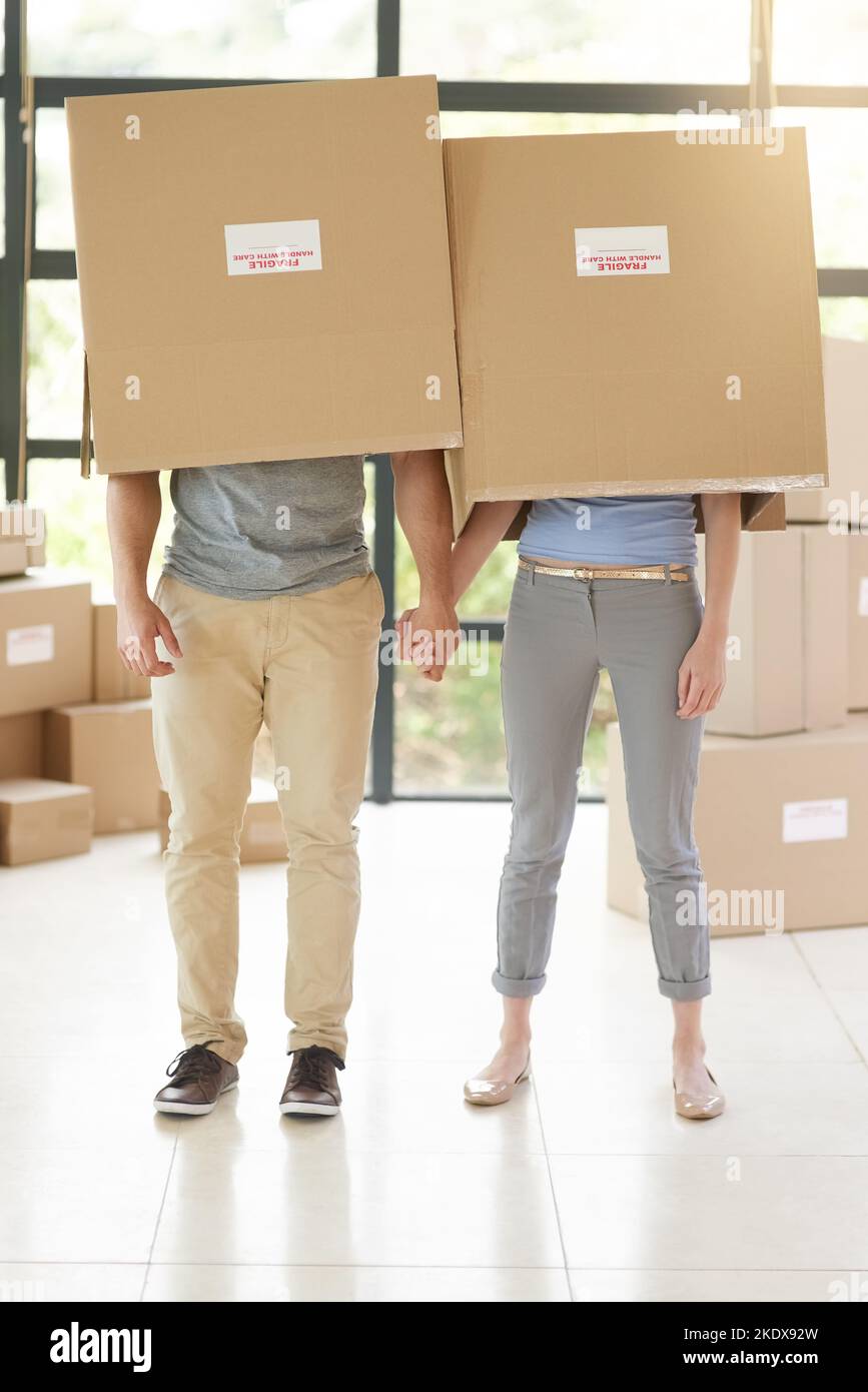 Having fun while unpacking. a carefree young couple posing with boxes ...