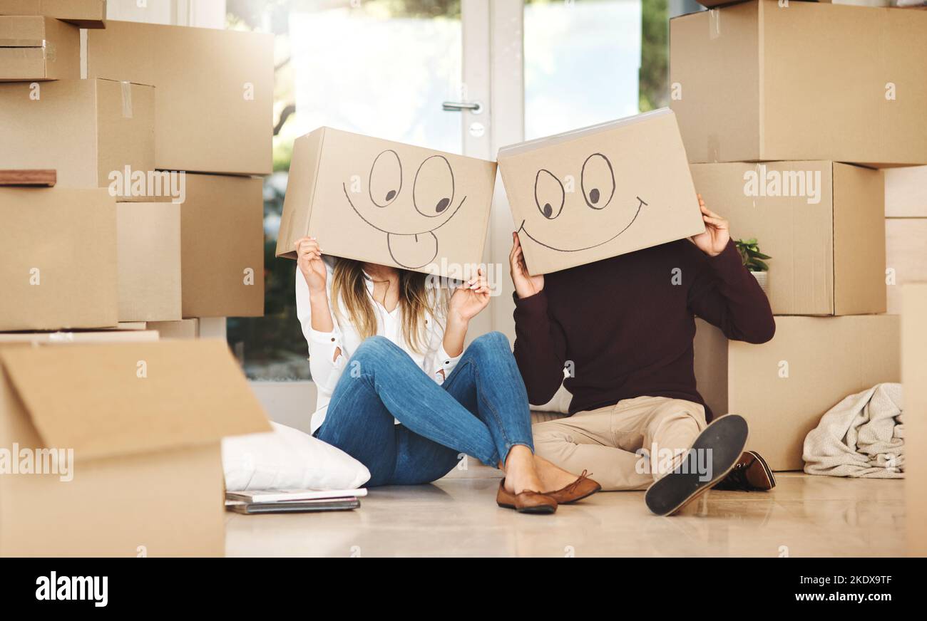 Making the most of moving day. a young couple day wearing boxes with ...