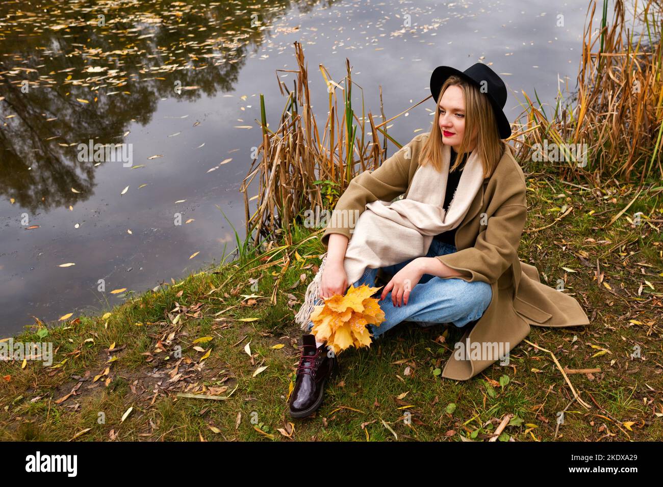 Young woman in coat, scarf and hat in autumn season. Girl with bouquet ...