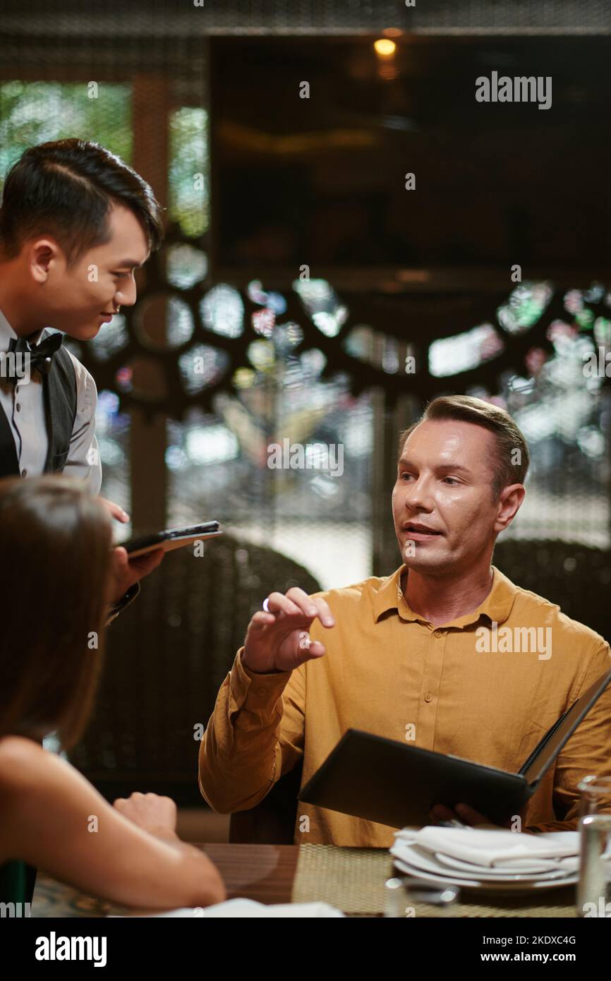 Man ordering food in restaurant for him and his family Stock Photo - Alamy