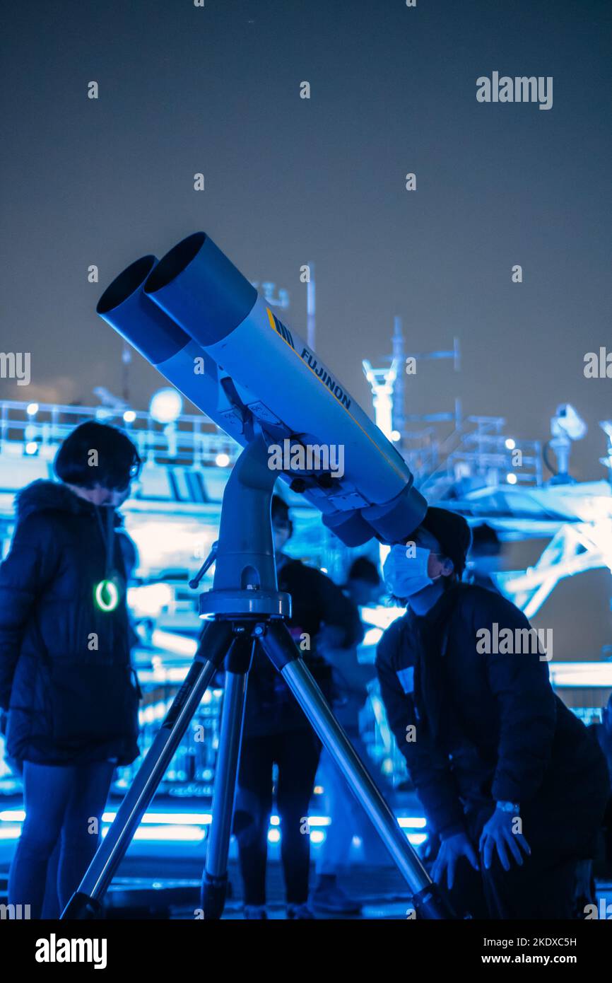 Tokyo, Japan. 8th Nov, 2022. People watch the lunar eclipse with a ...