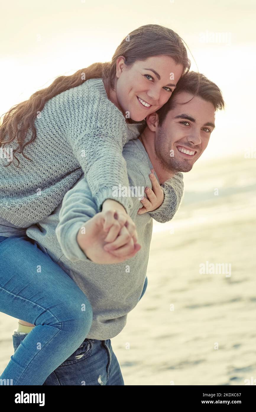 Love makes us lighthearted. Portrait of a happy young man giving his girlfriend a piggyback ride ...