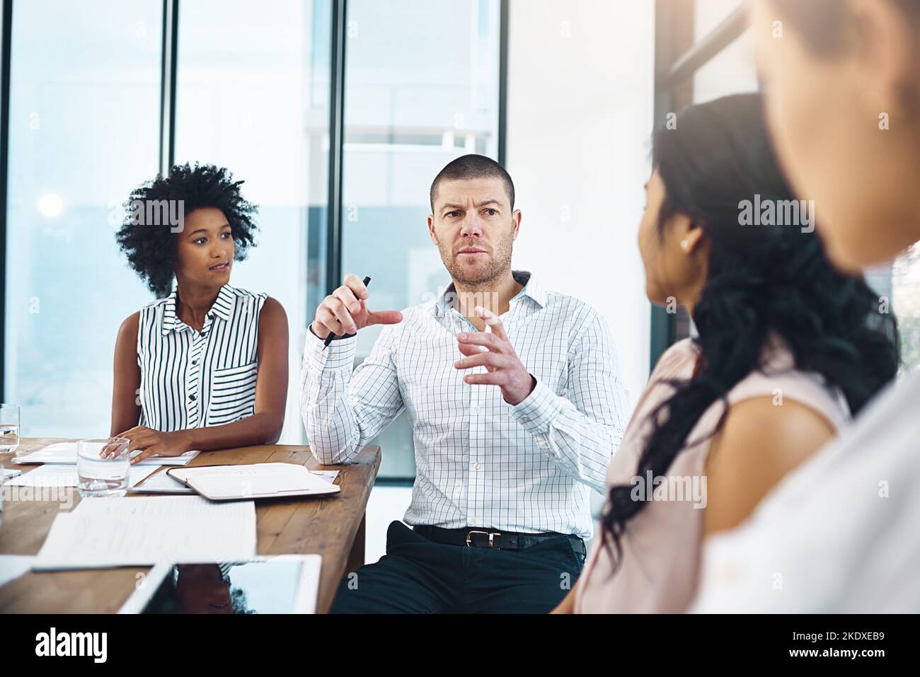 Outlining his perspective. a group of colleagues having a meeting in a ...