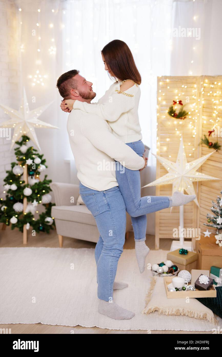 Strong man lifted the woman up in christmas decorated room Stock Photo ...