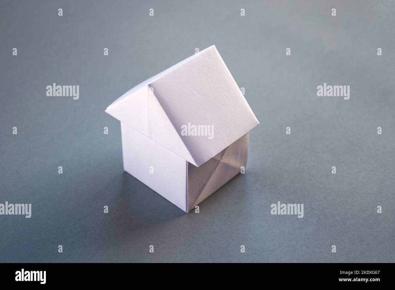 White paper house origami isolated on a blank grey background Stock ...