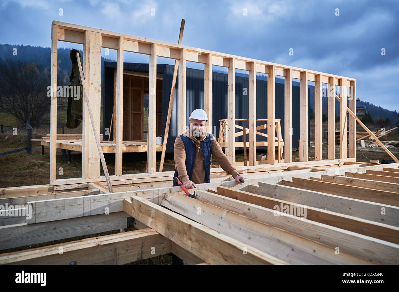 Male architect building wooden frame house. Man standing on ...