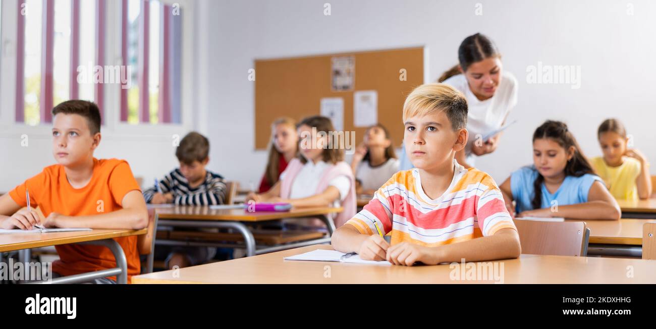 Smart boy writing during class in school Stock Photo - Alamy
