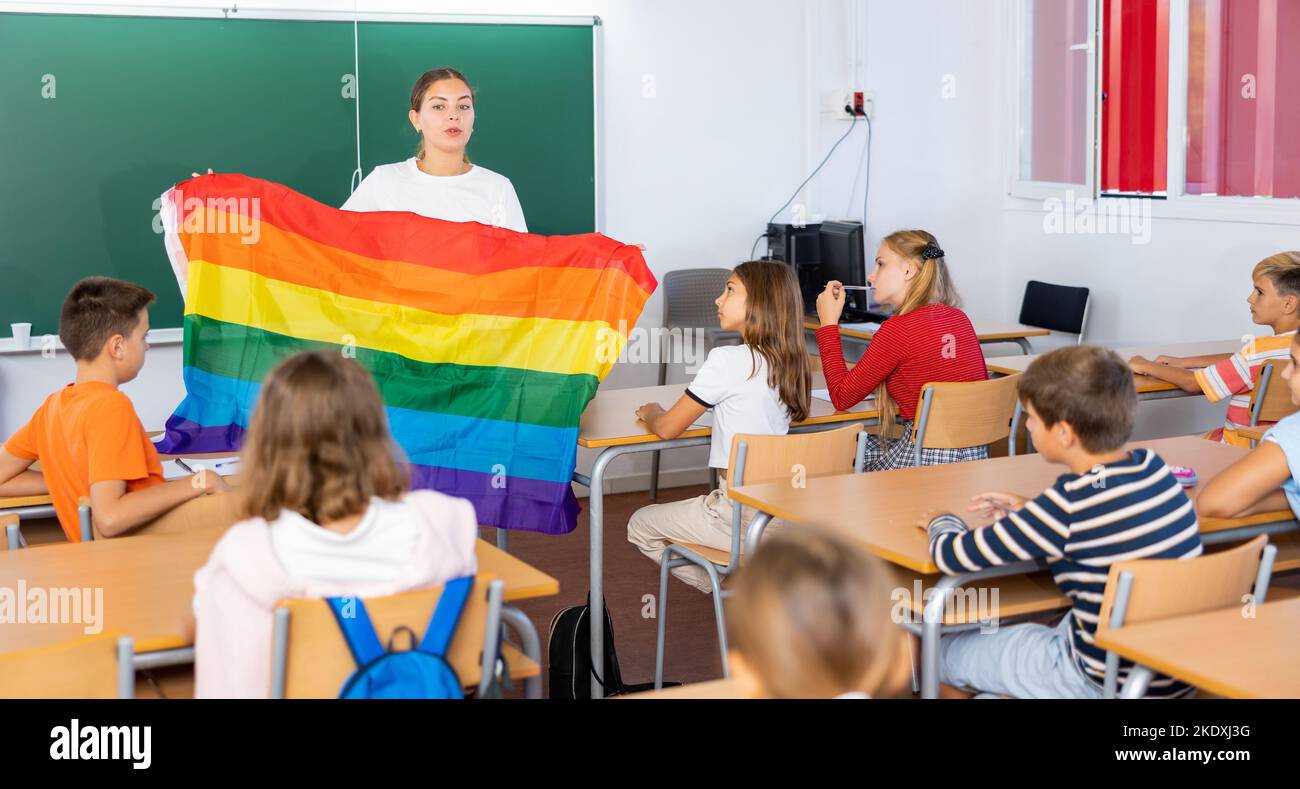 Female teacher explaining lgbt theme to children during lesson in class ...