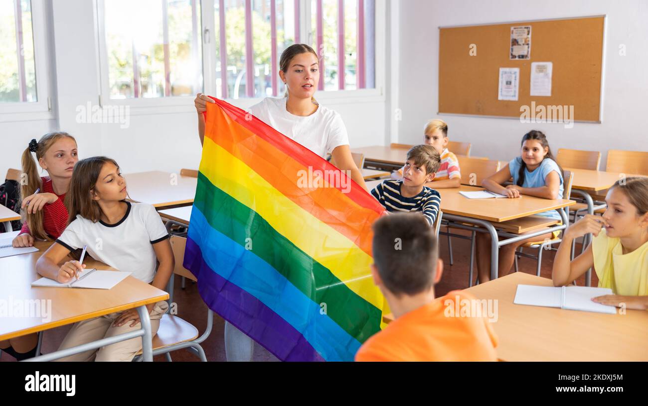 Children sitting in classroom and listening to female teacher. She ...
