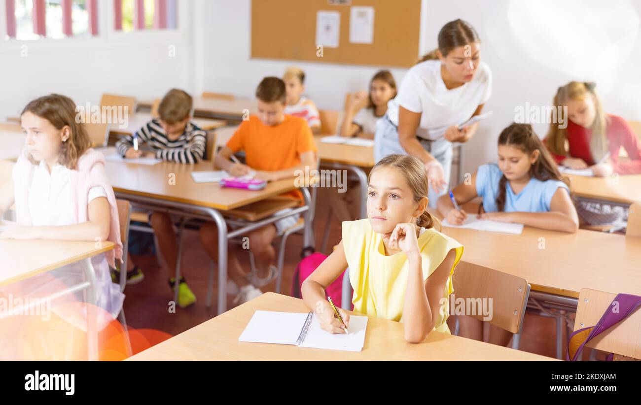 Smart girl studying in classroom with pupils Stock Photo - Alamy