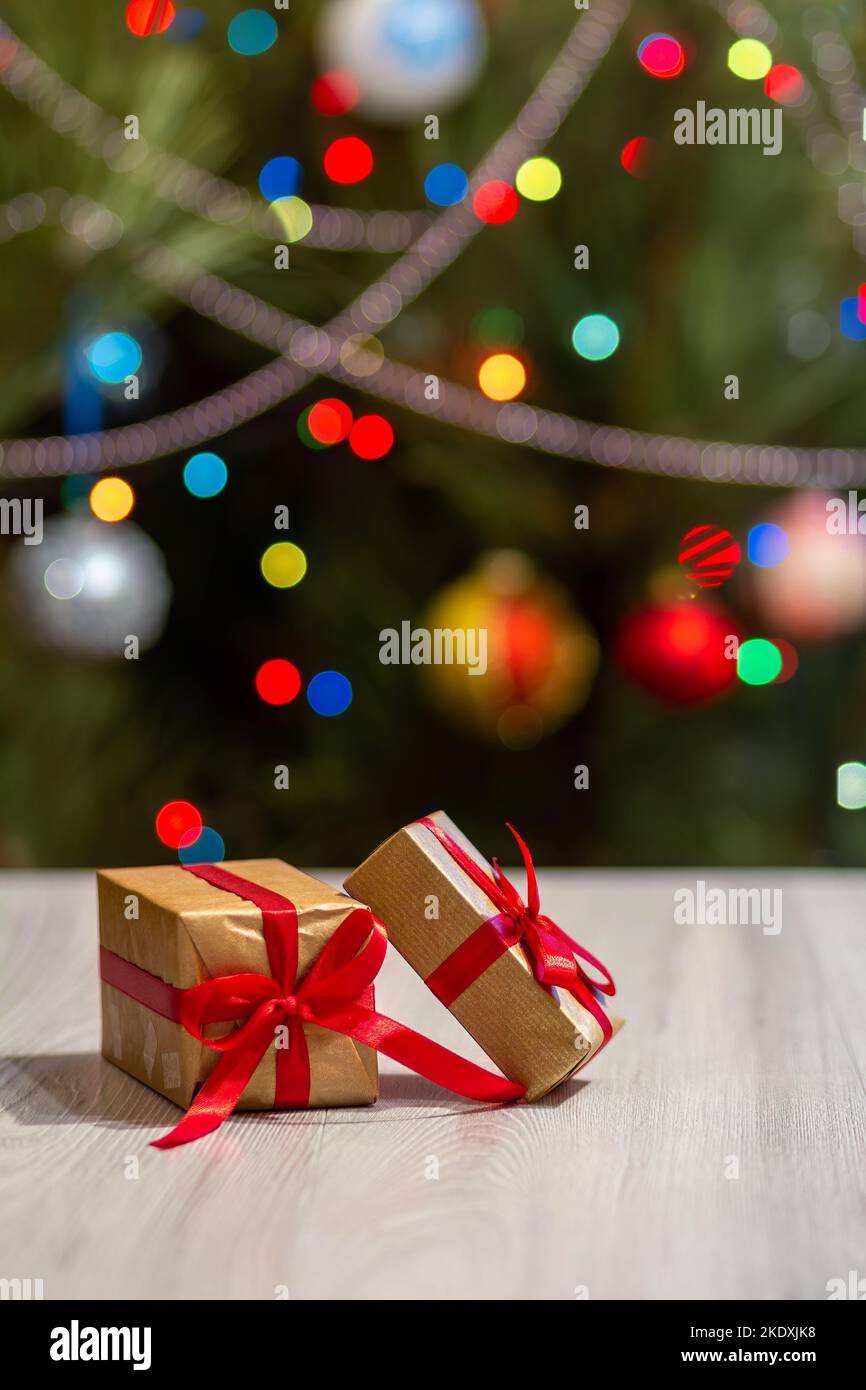 Gift boxes with red bows and blurred Christmas tree with twinkling ...