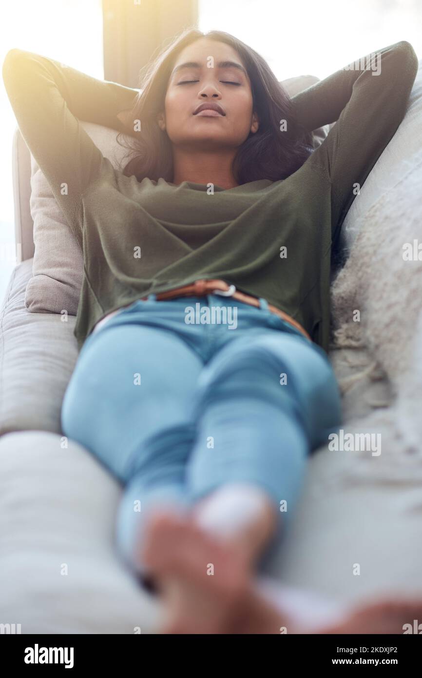 Some much needed relaxation. an attractive young woman relaxing on her ...