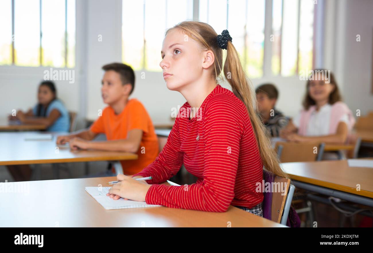 Portrait of school girl who writing exercises at lesson in school Stock ...