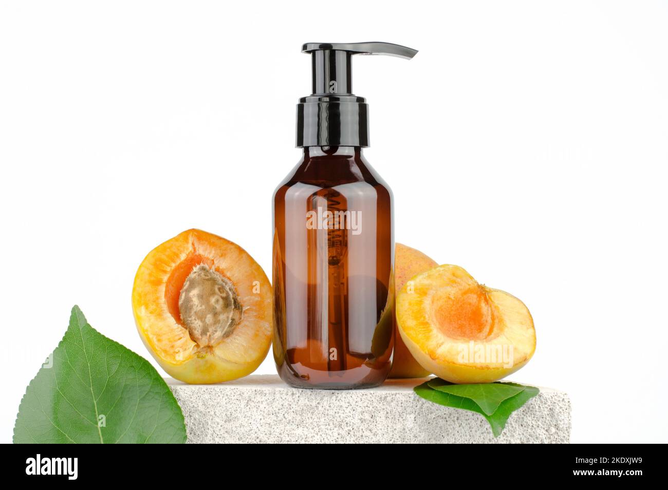 Apricot liquid soap. Brown bottle with dispenser and fresh apricots on ...