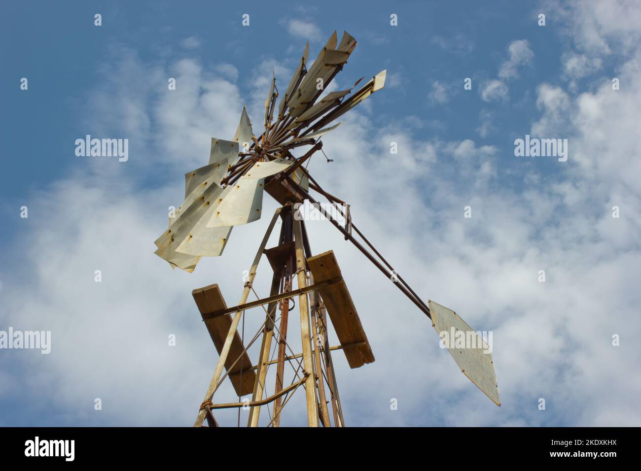 Top of old windmill with platform against white clouds and blue skies ...