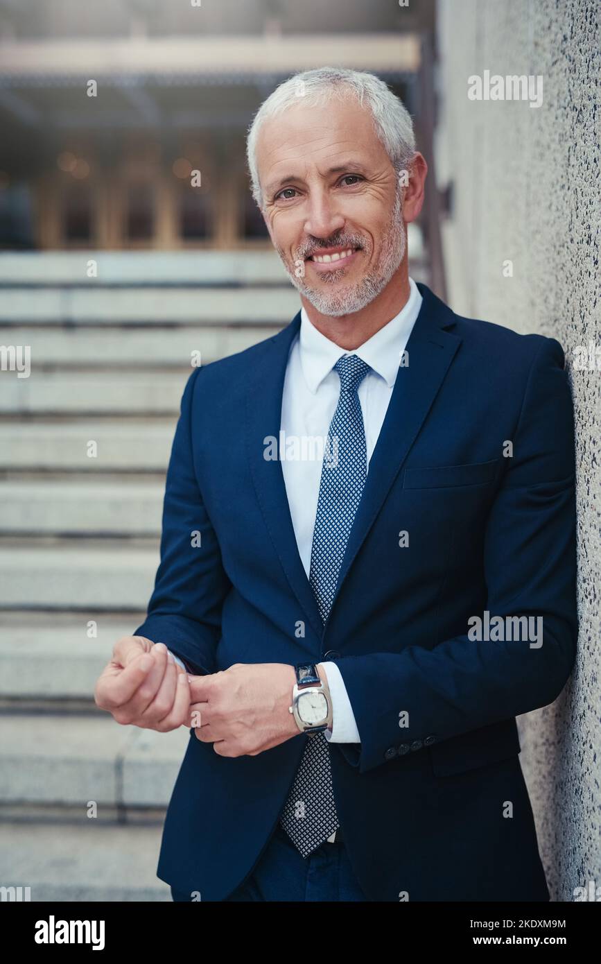 Dress like youre trying to impress. Portrait of a well dressed businessman standing outside his ...