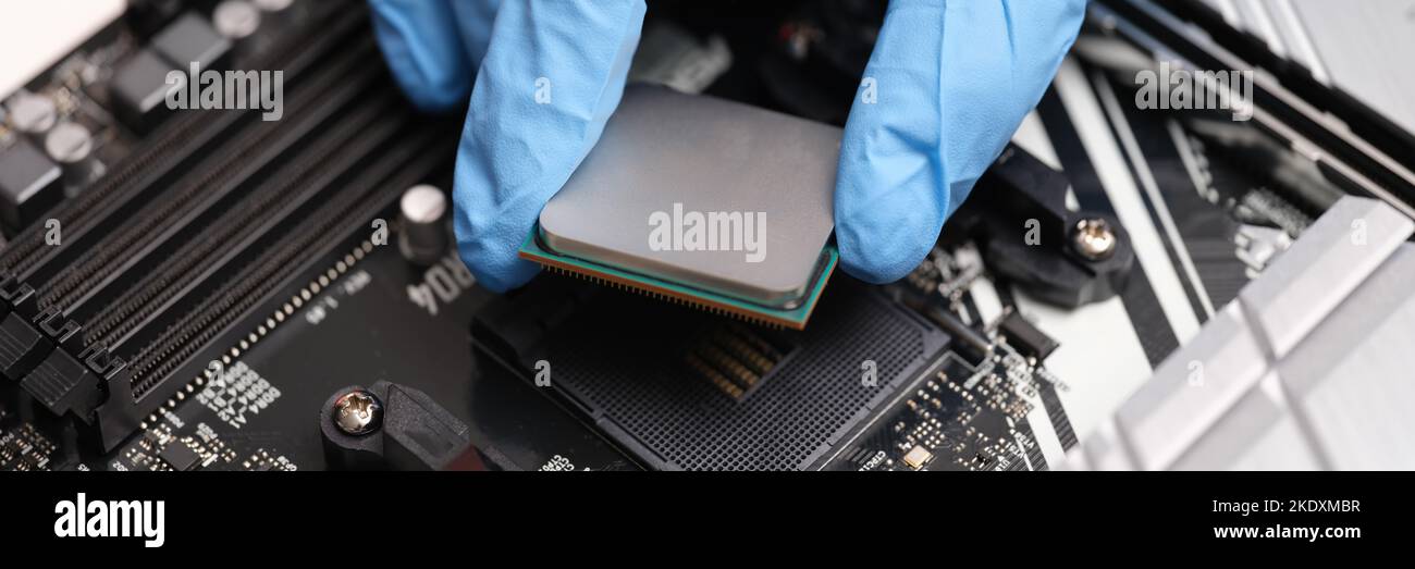 Engineer hand sets the processor to the motherboard Stock Photo - Alamy