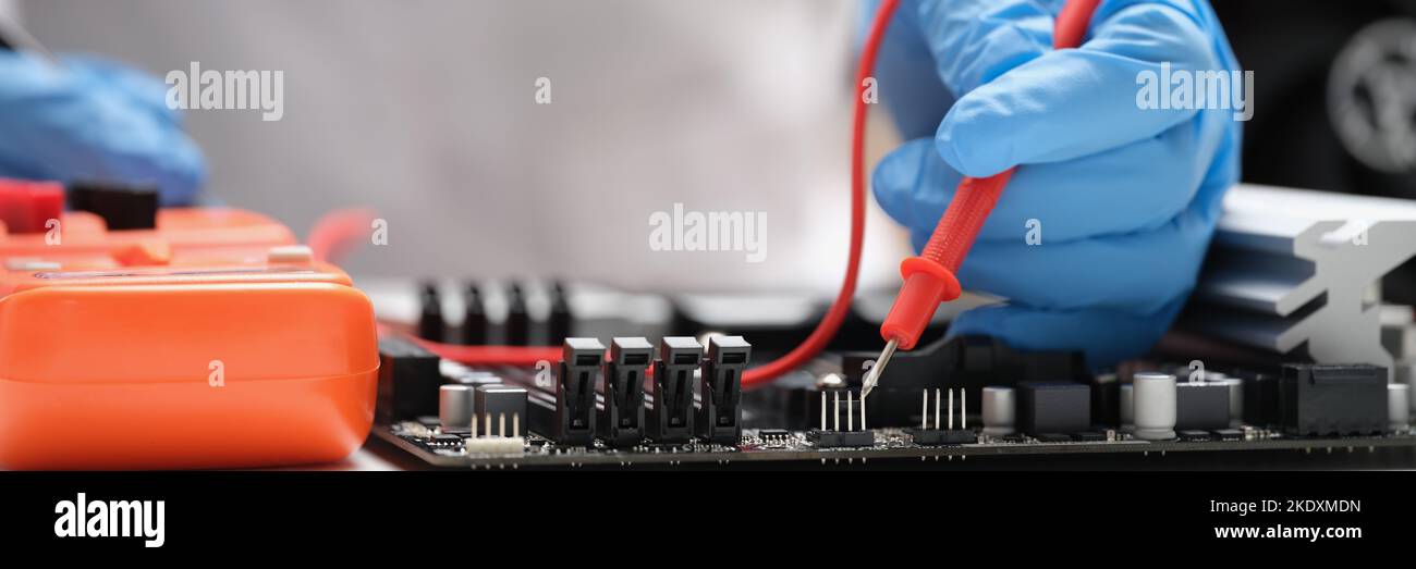 Technician measuring voltage of in computer mainboard using electronic ...
