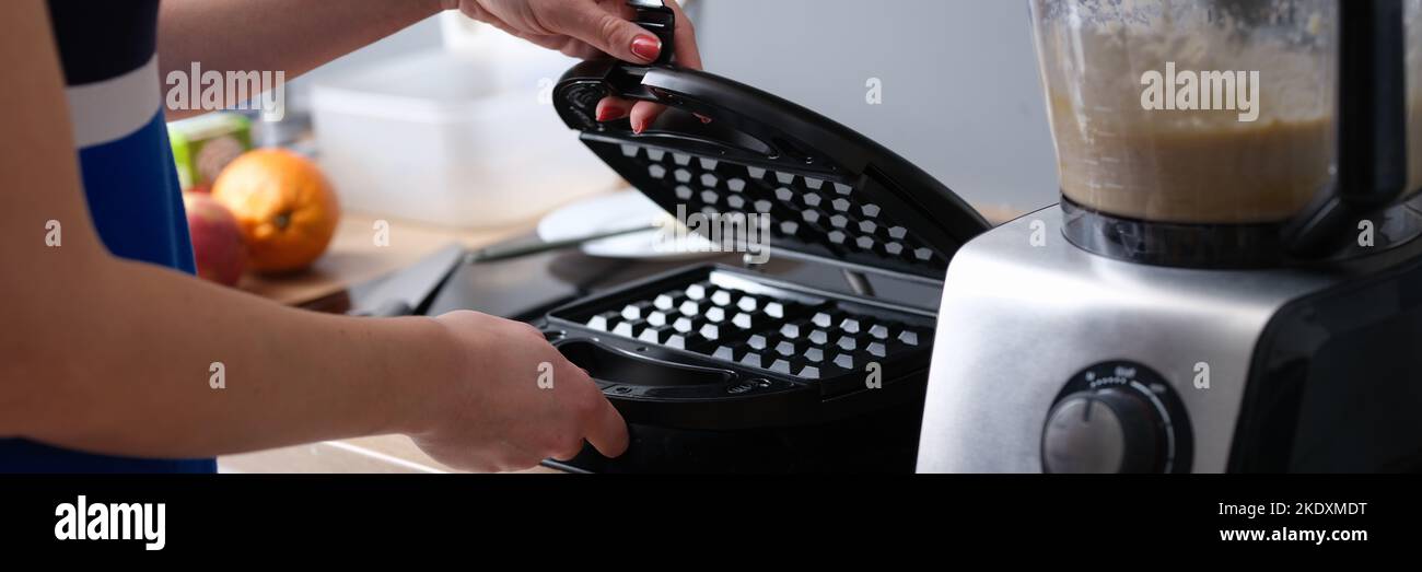 Woman preparing belgian waffle maker in kitchen Stock Photo - Alamy