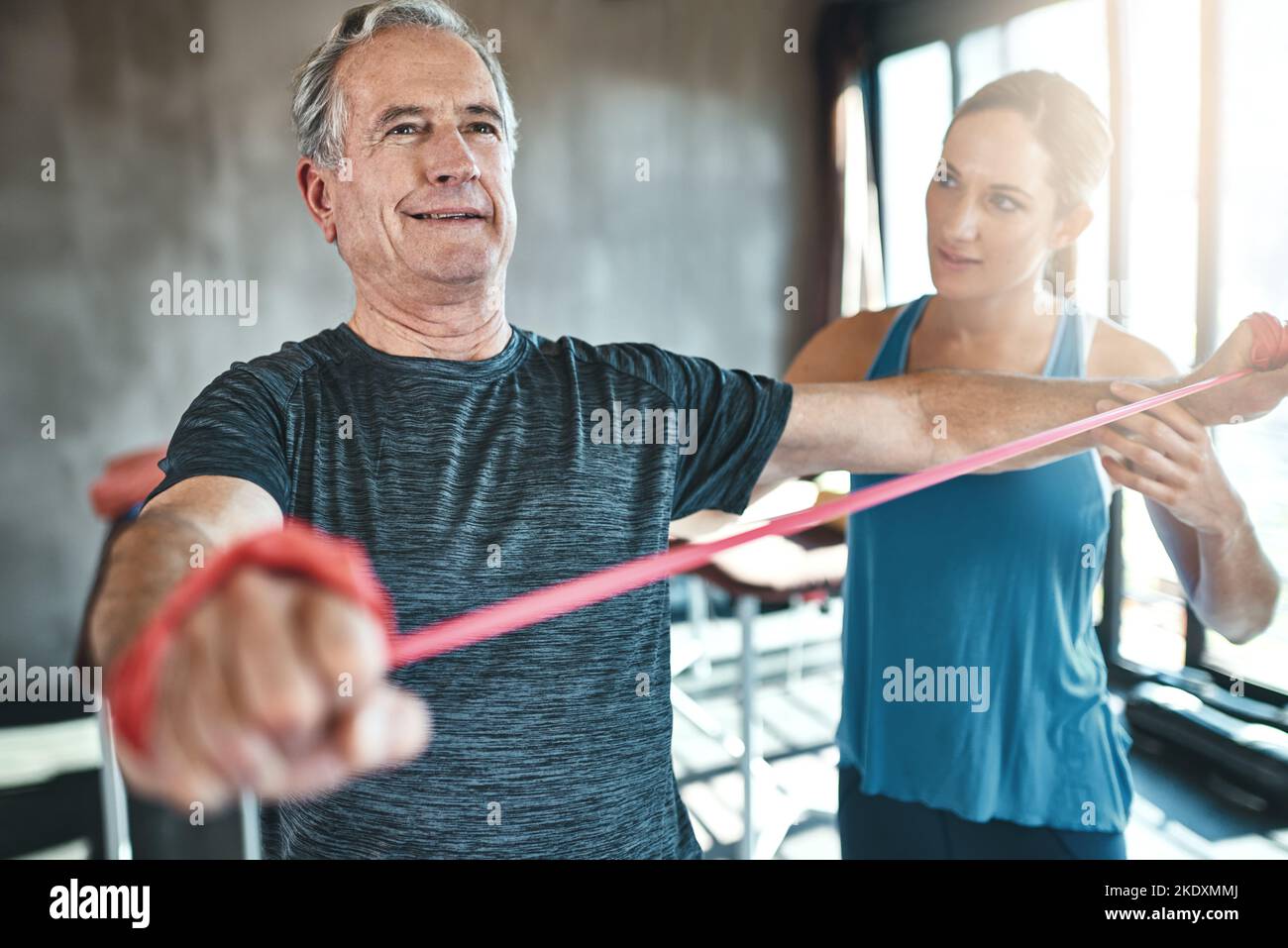 Exercise is vital for healthy aging. a senior man using resistance ...