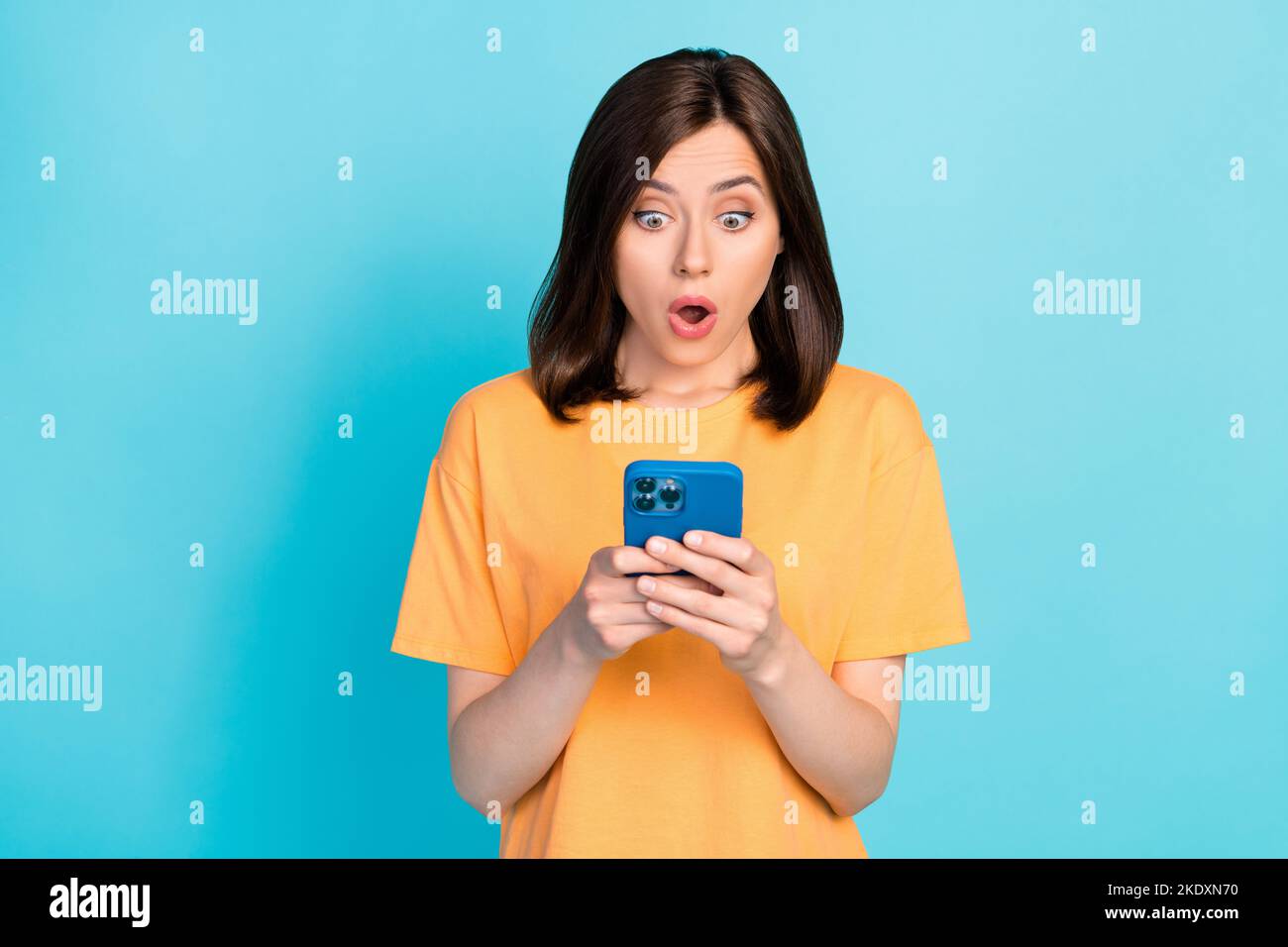 Photo of impressed pretty girl open mouth use telephone typing isolated ...