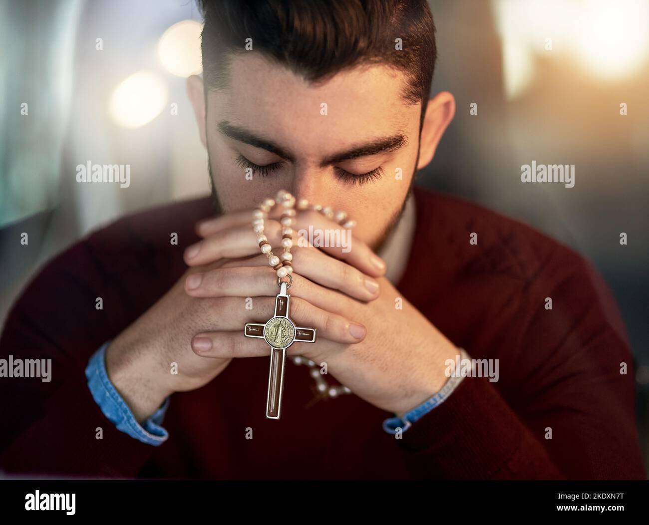 Calling out to a higher power. a young man praying on his own while ...