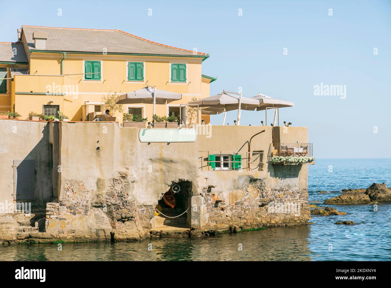 Exterior stone building with cafe terrace and low rise house above ...