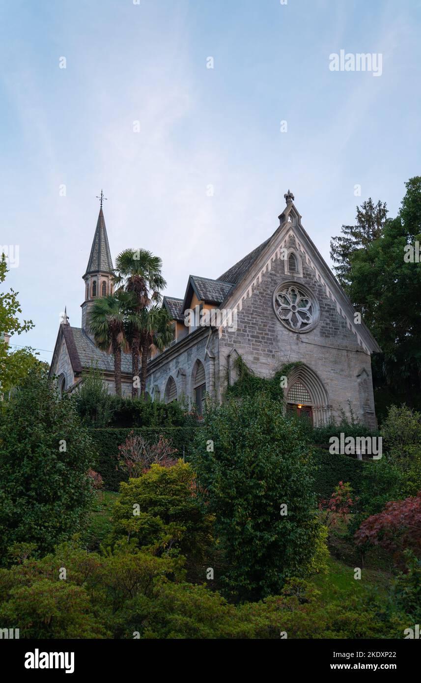 Exterior of ancient stone church with arched windows located on hill ...
