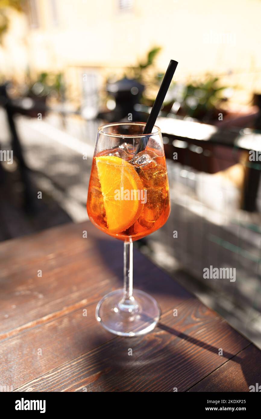 Served cocktail of Aperol spritz with orange slice and straw placed on ...