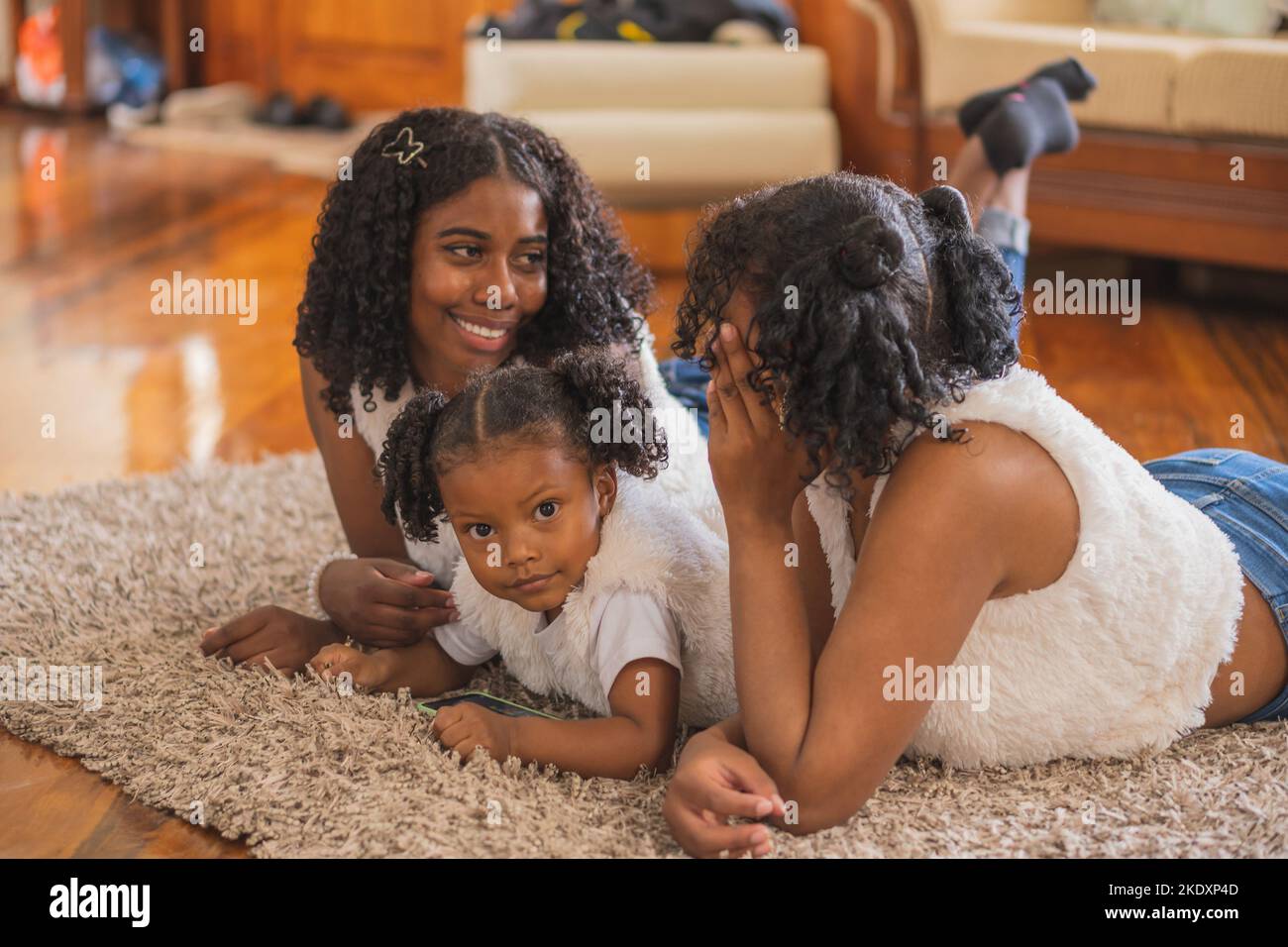 Focused Indian Sisters With Curly Hair Looking At Each Other While