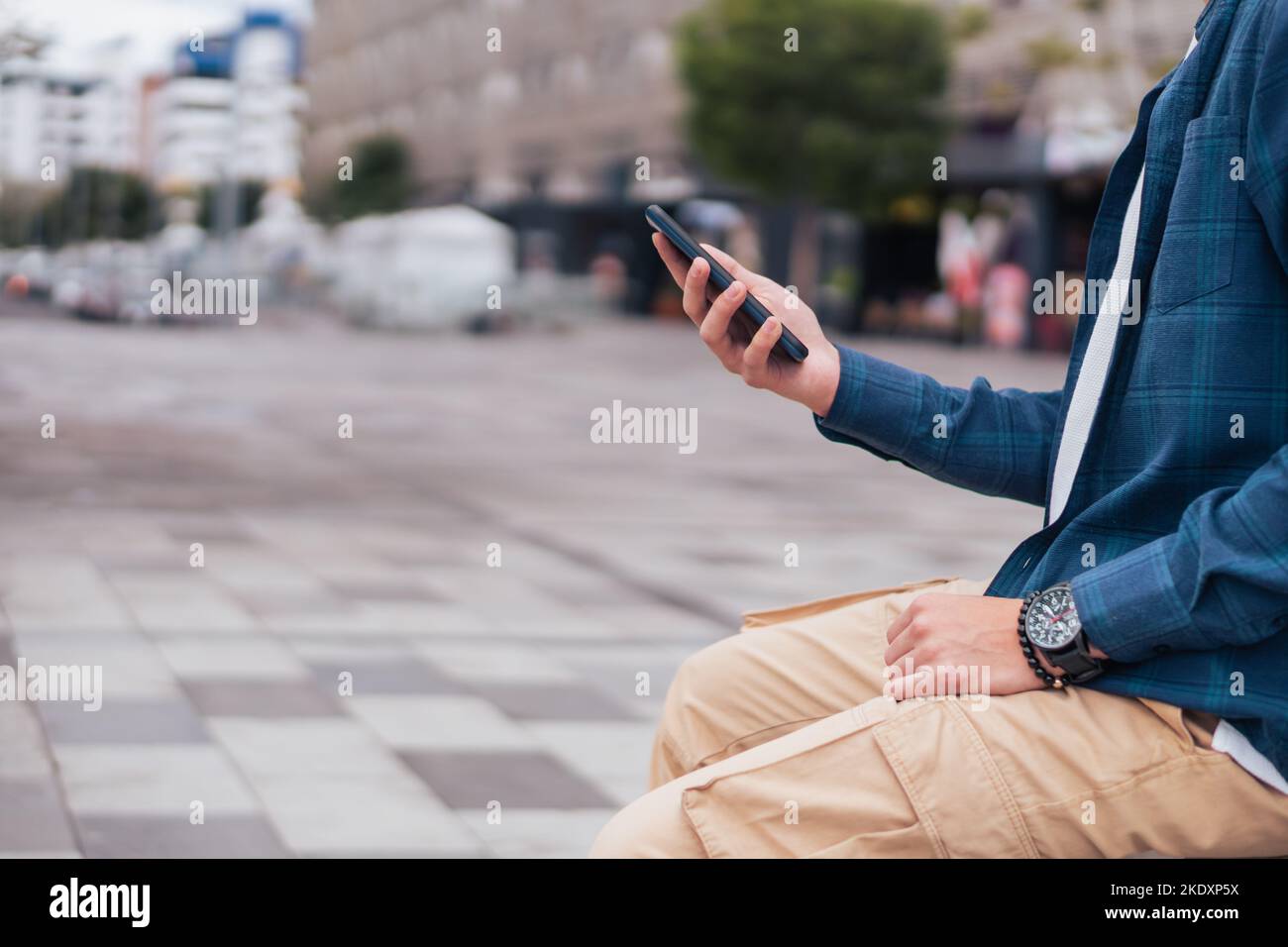 Cropped unrecognizable young man in casual clothes with smartphone ...
