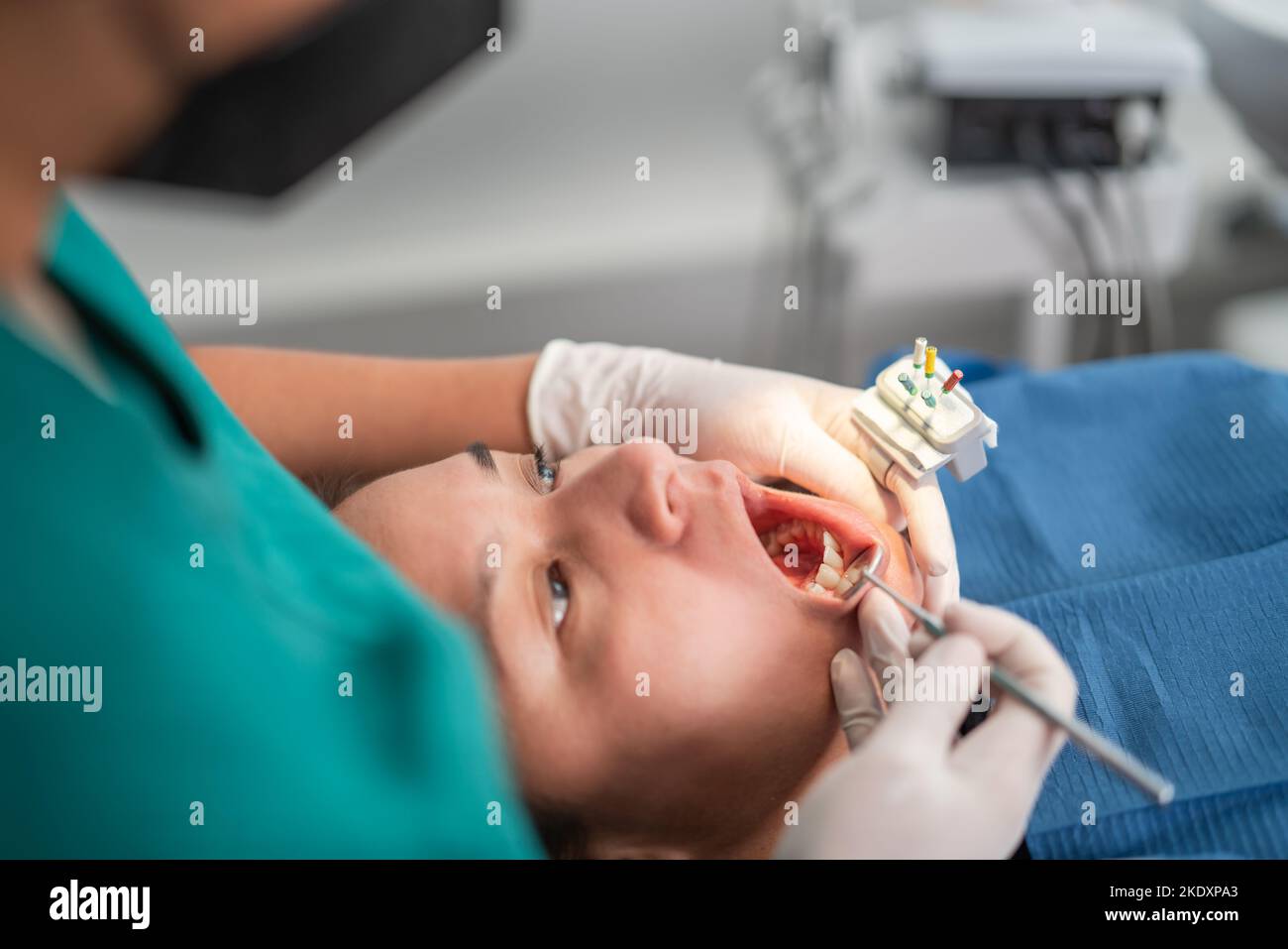 From above of crop unrecognizable dentist using examination mirror and ...