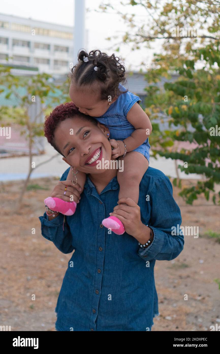 Optimistic Colombian mother in denim shirt with short hair smiling and ...
