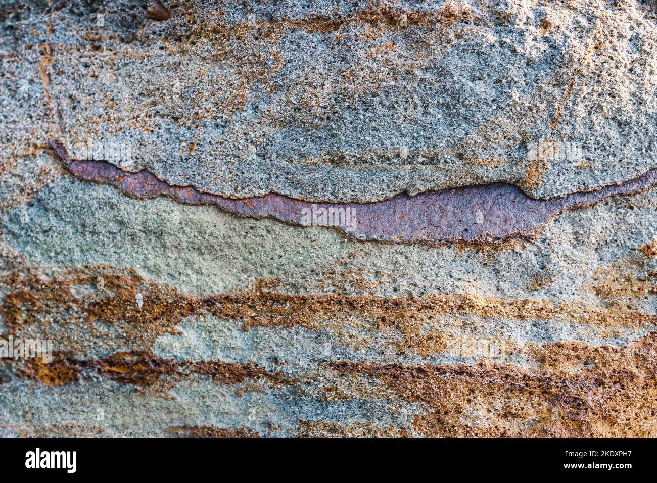 Full frame background of uneven rock cliff with crack in daytime in ...