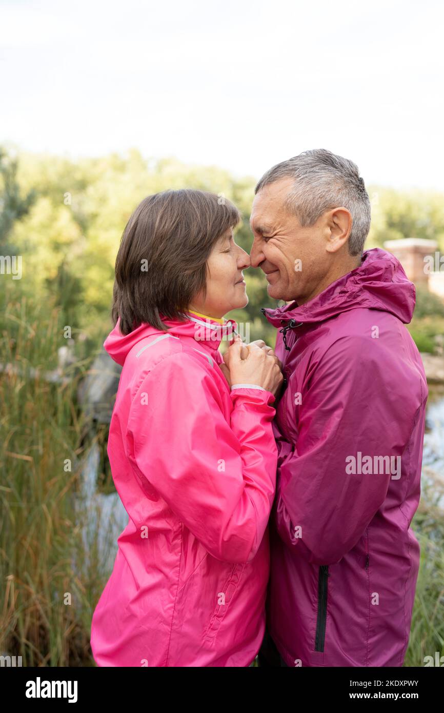 Side view of middle aged man and woman clasping hands and touching ...