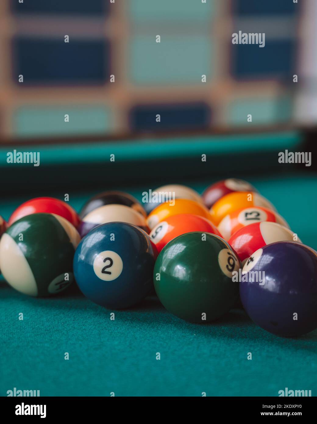 Table for pool game with shiny balls and cues against bar counter in ...