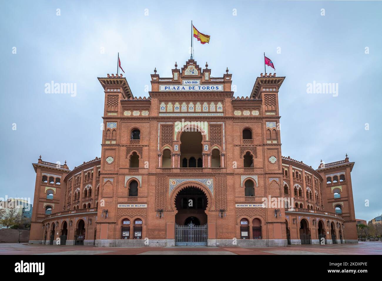 Ancient building for bullfights with arched windows and national flags ...