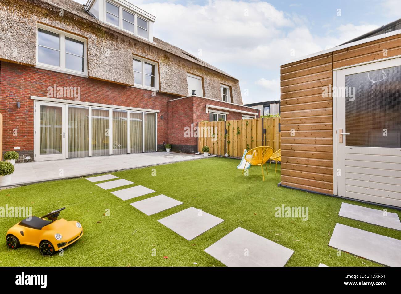 Residential brick building with glass doors located on tiled terrace ...