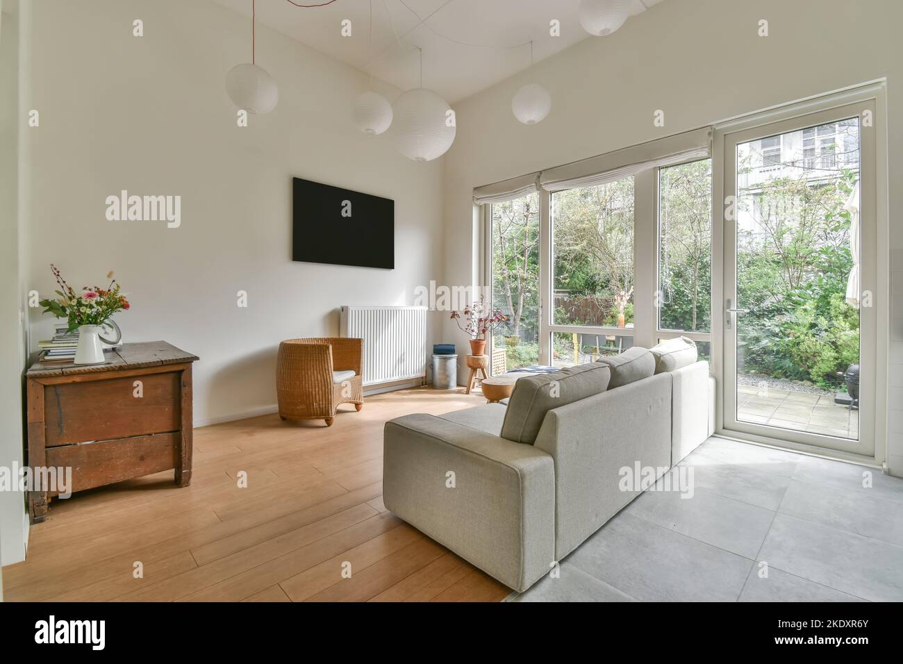 Interior of sunlit living room with sofa and television located near ...