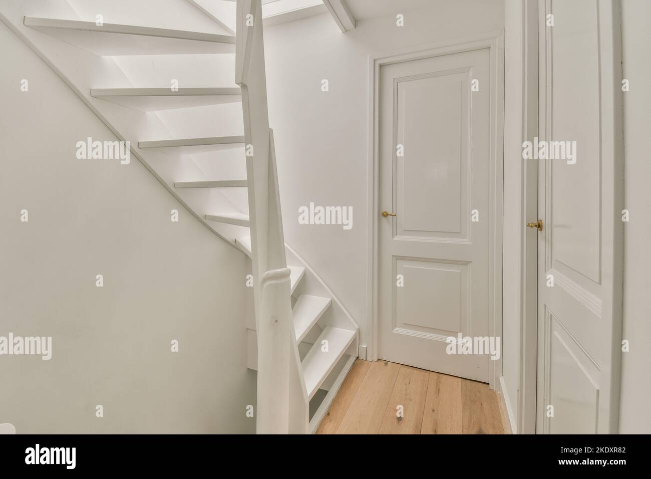 Long staircase with railing located in corridor of apartment with white ...